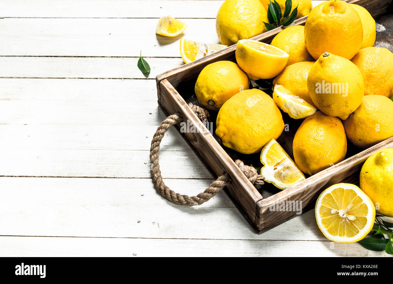 Fresh lemons on a tray. On a white wooden table Stock Photo - Alamy