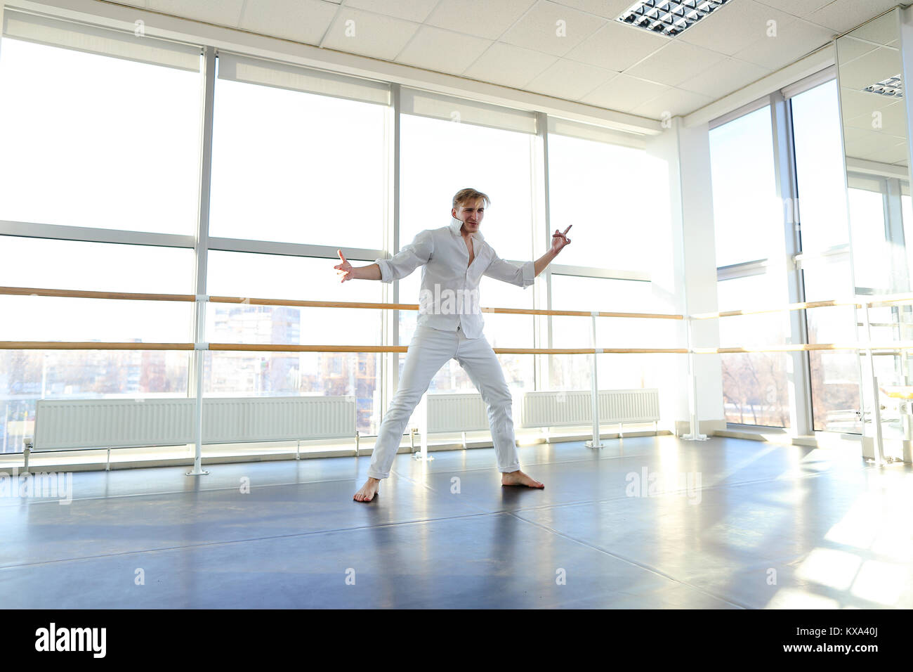Guy spotting in white suit and raving at studio Stock Photo - Alamy