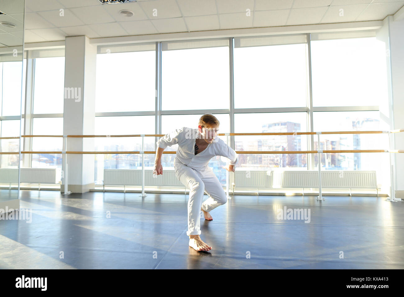 Young blonde dancer enjoys winning in white suit and makes warm Stock ...