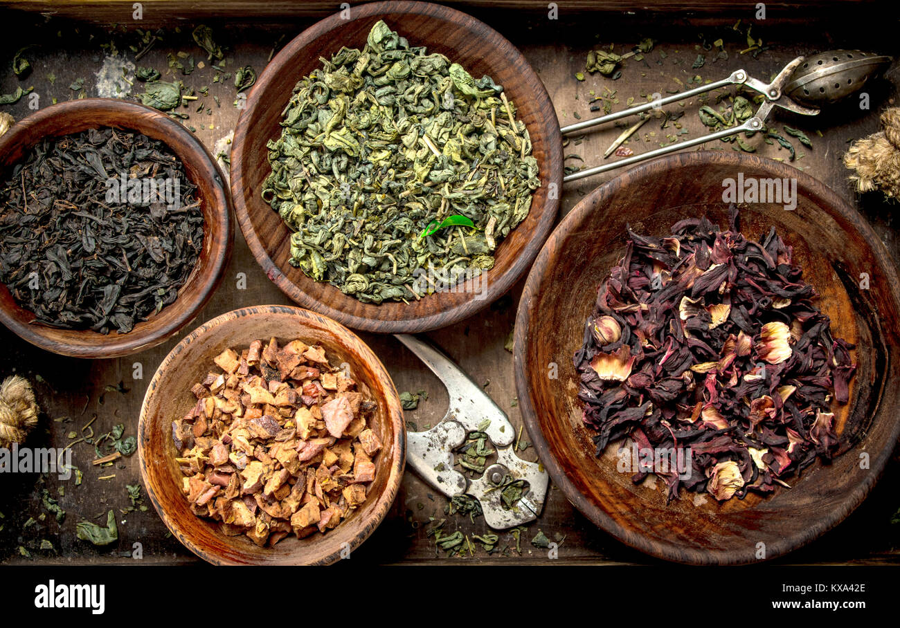 Different kinds of fragrant tea in bowls. On a rustic background Stock ...