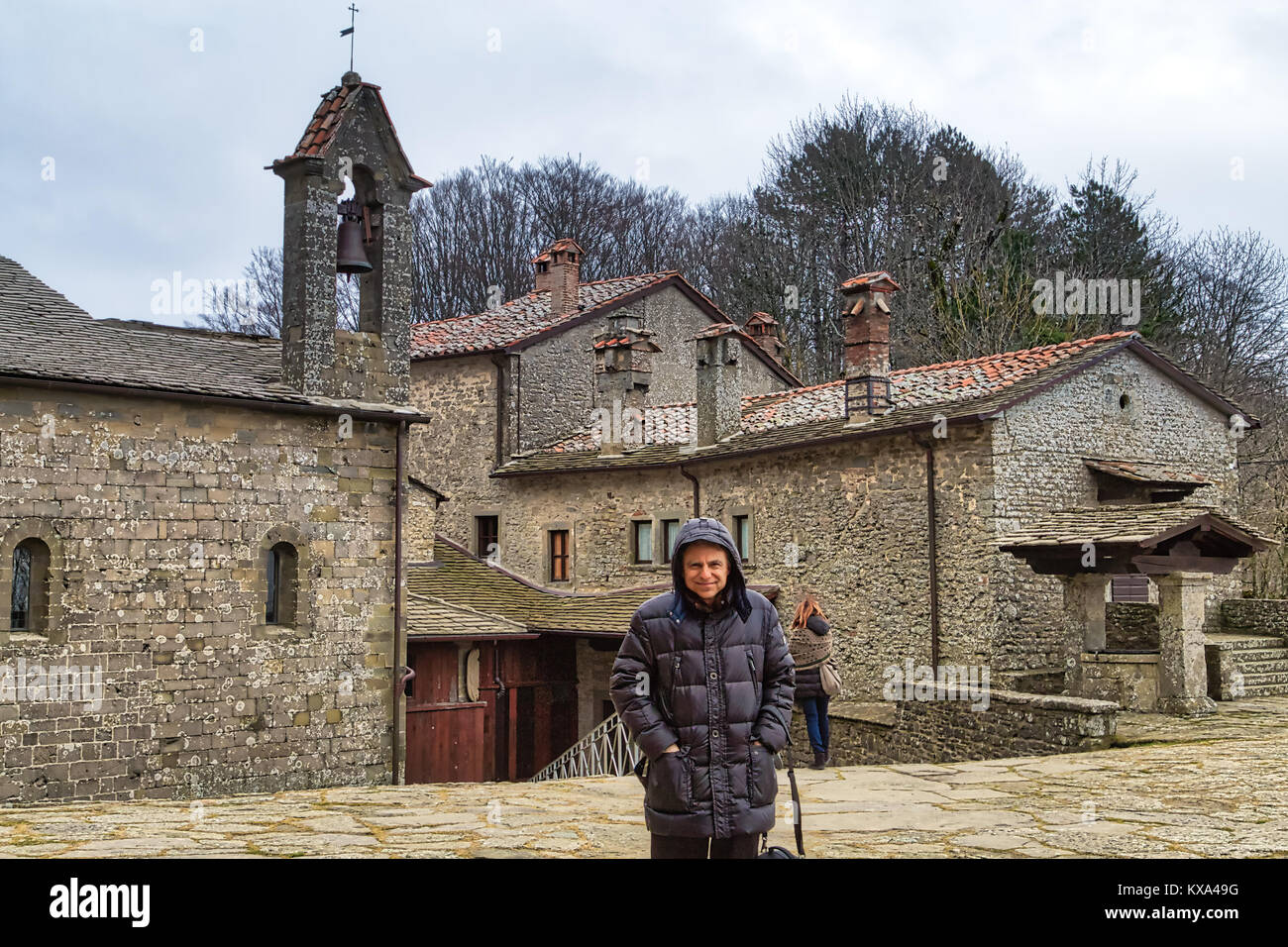 Old Pilgrim with ancient walls of Franciscan sanctuary in the Tuscan ...