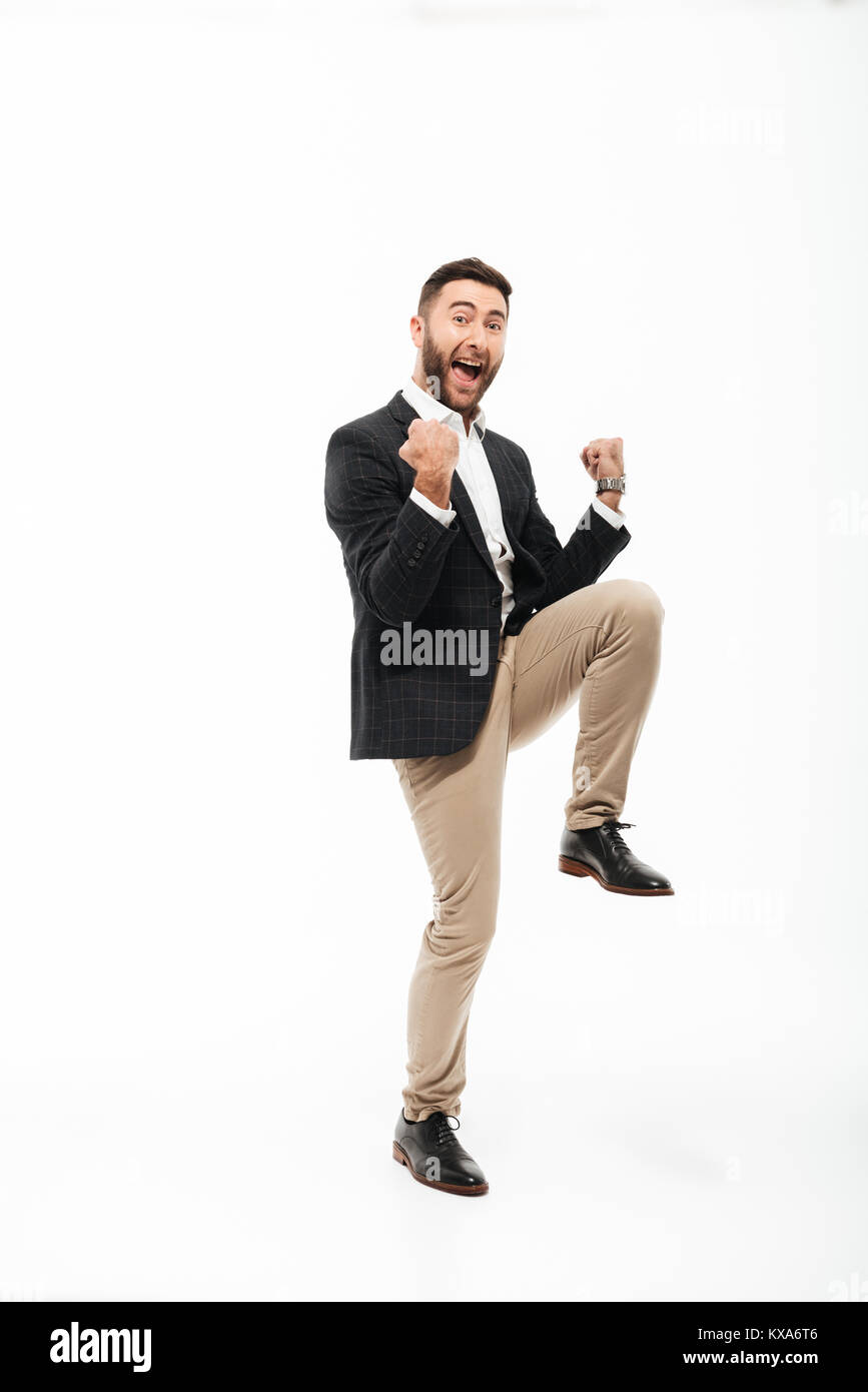 Full length portrait of a cheery happy man celebrating success isolated ...