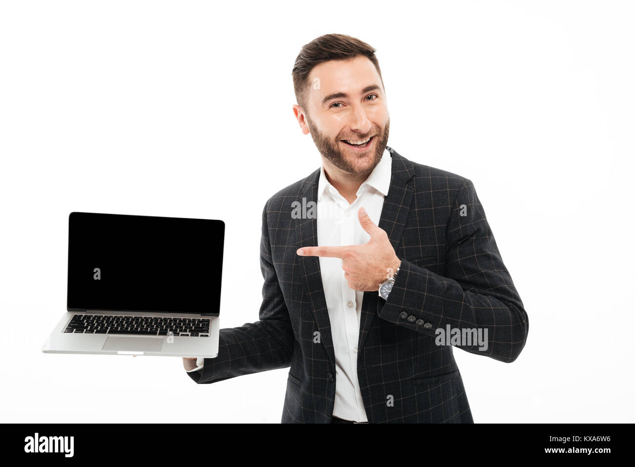 Portrait of a cheerful bearded man pointing finger at blank screen ...
