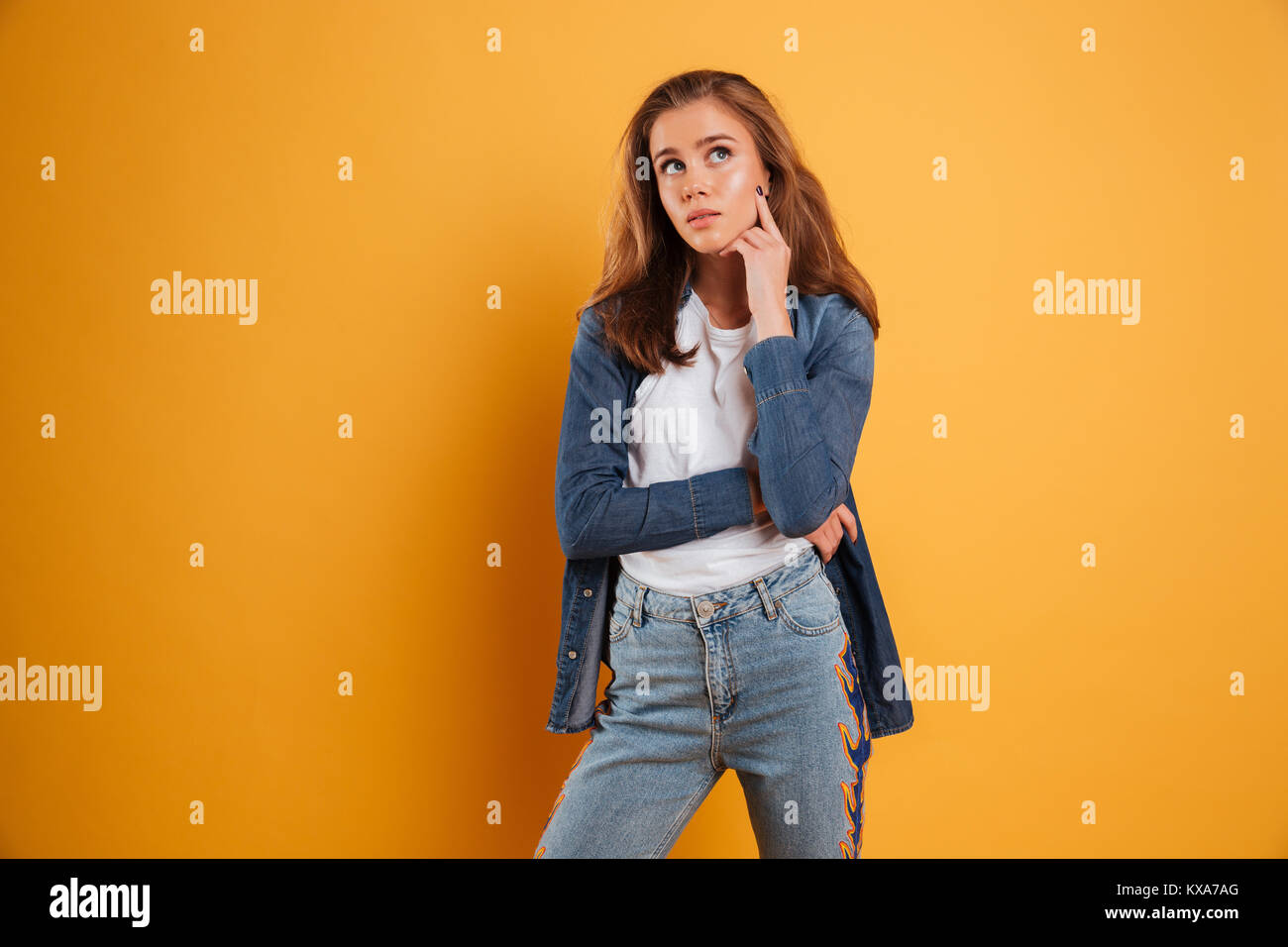 Portrait of a pretty casual girl thinking and looking away at copy ...
