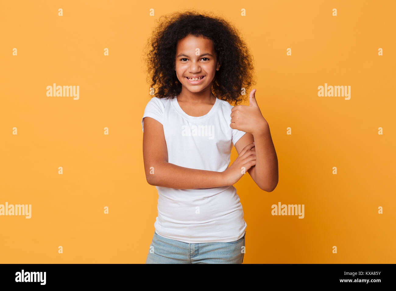 Portrait of a happy little african girl showing thumbs up gesture ...