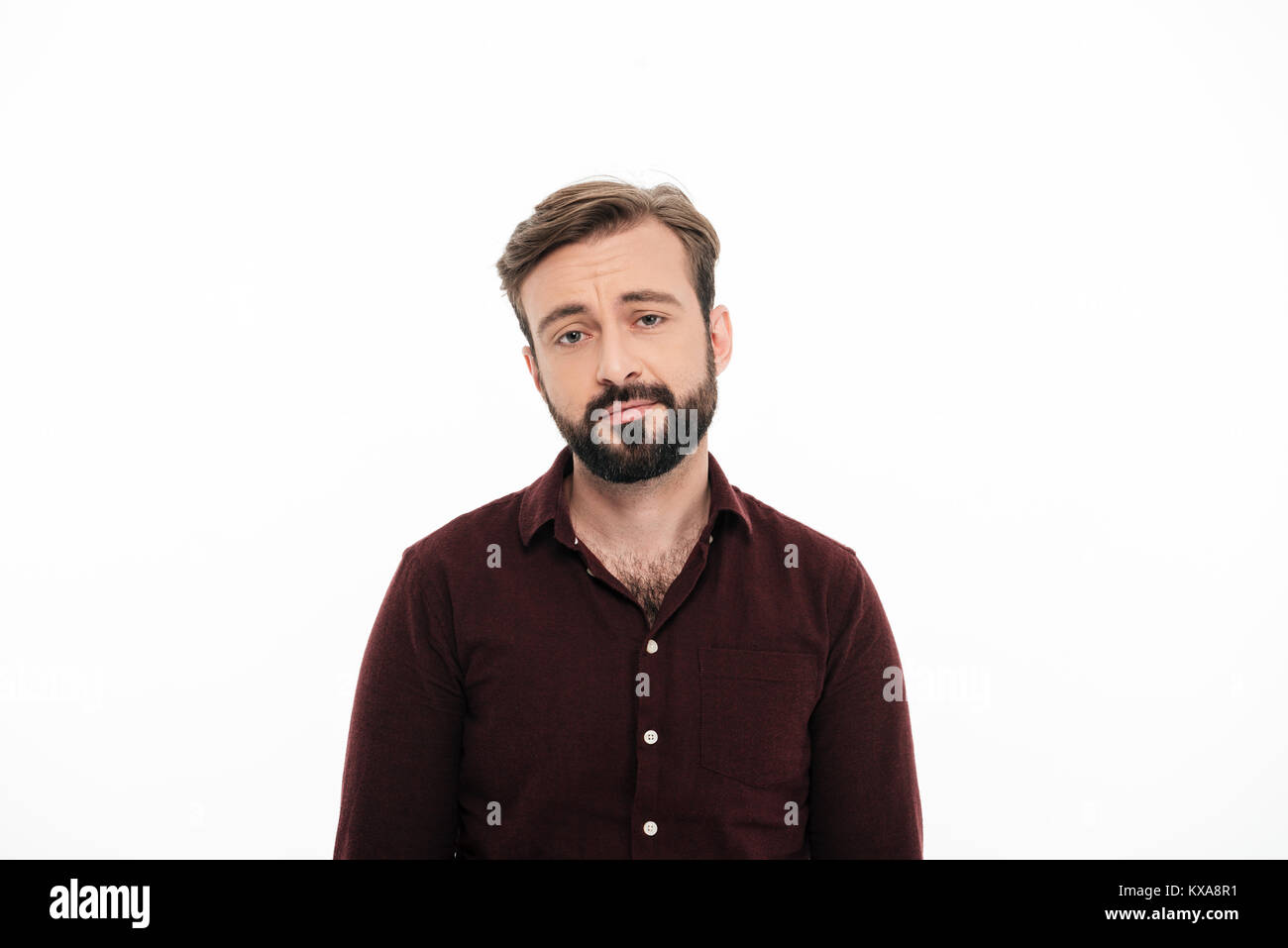 Portrait of a charming young man looking at camera isolated over white ...