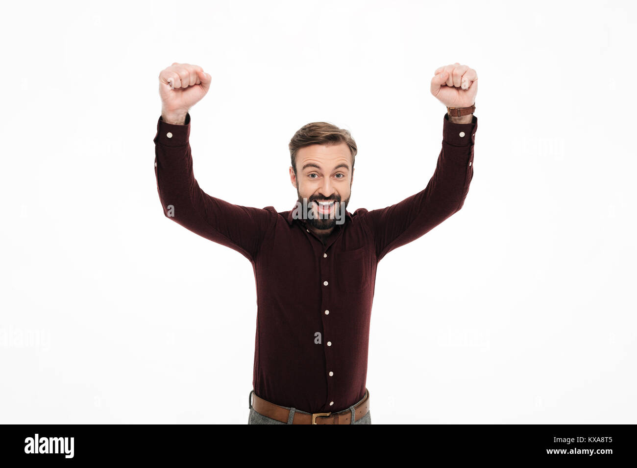 Portrait of a cheery happy man celebrating success with hands raised ...