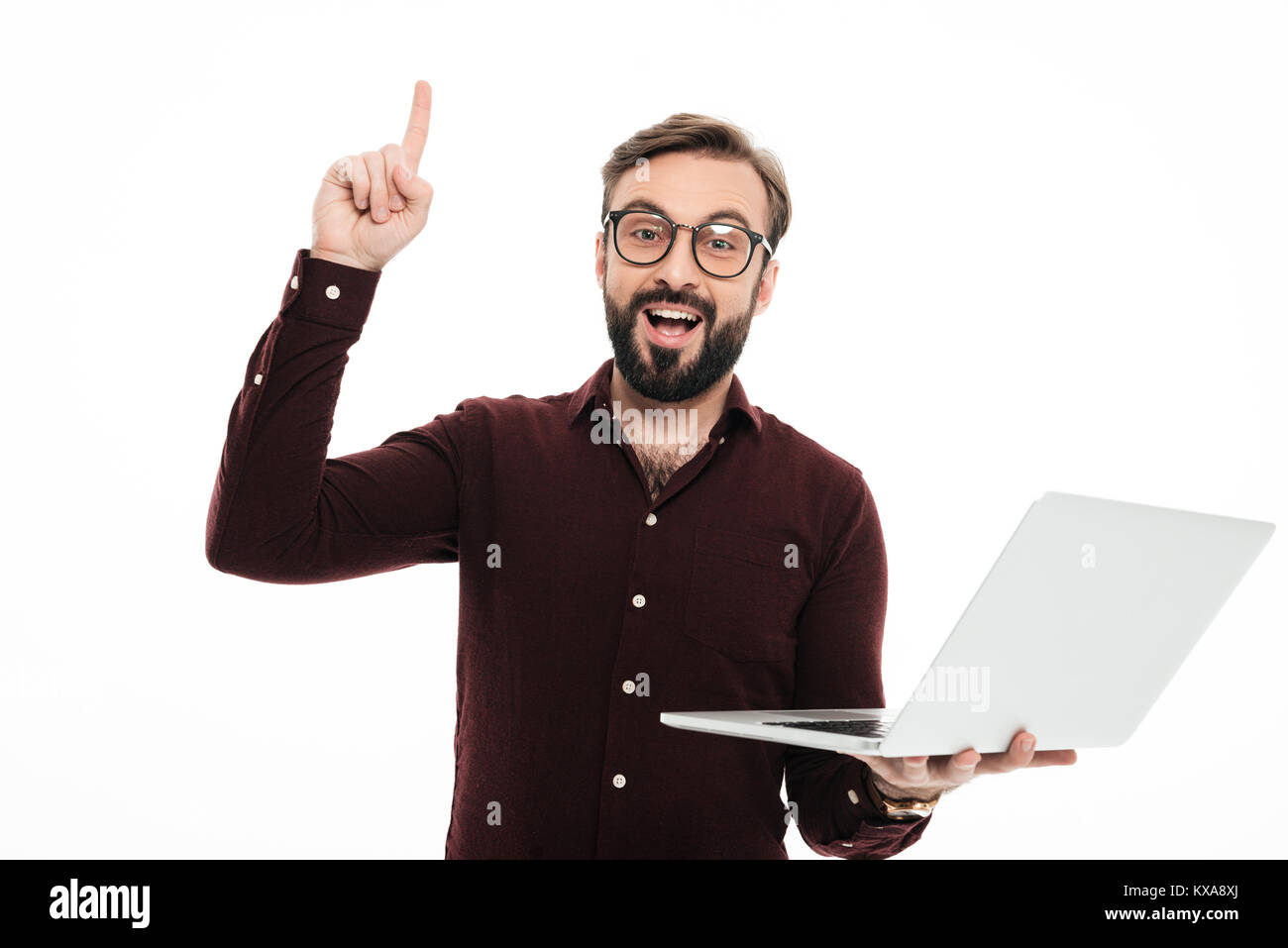 Portrait of an excited bearded man holding laptop computer and pointing ...