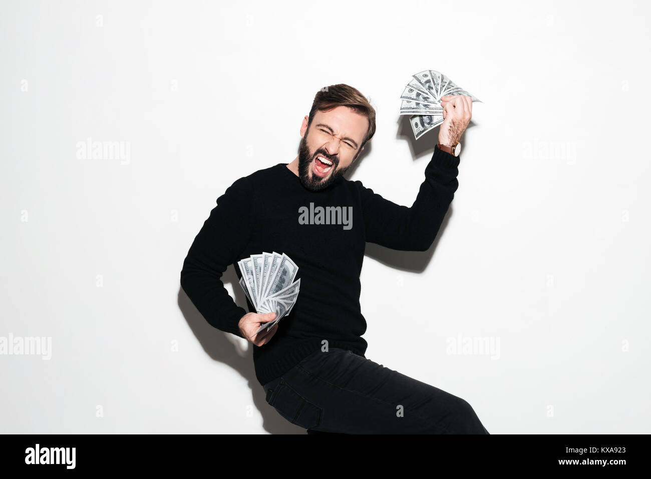 Portrait of a cheery successful man holding bunch of money banknotes ...