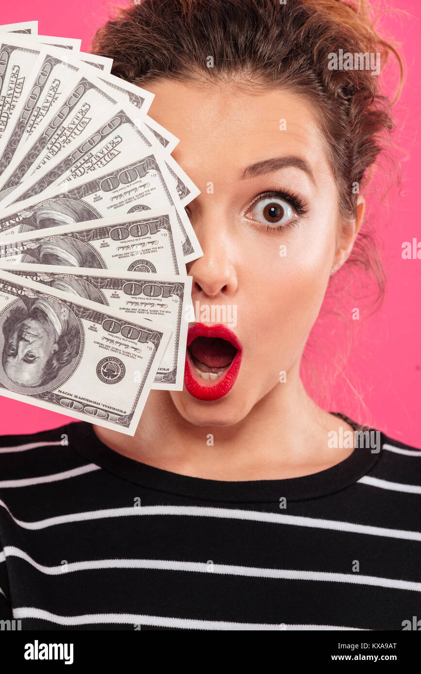 Close up portrait of an shocked woman covering her face with money ...