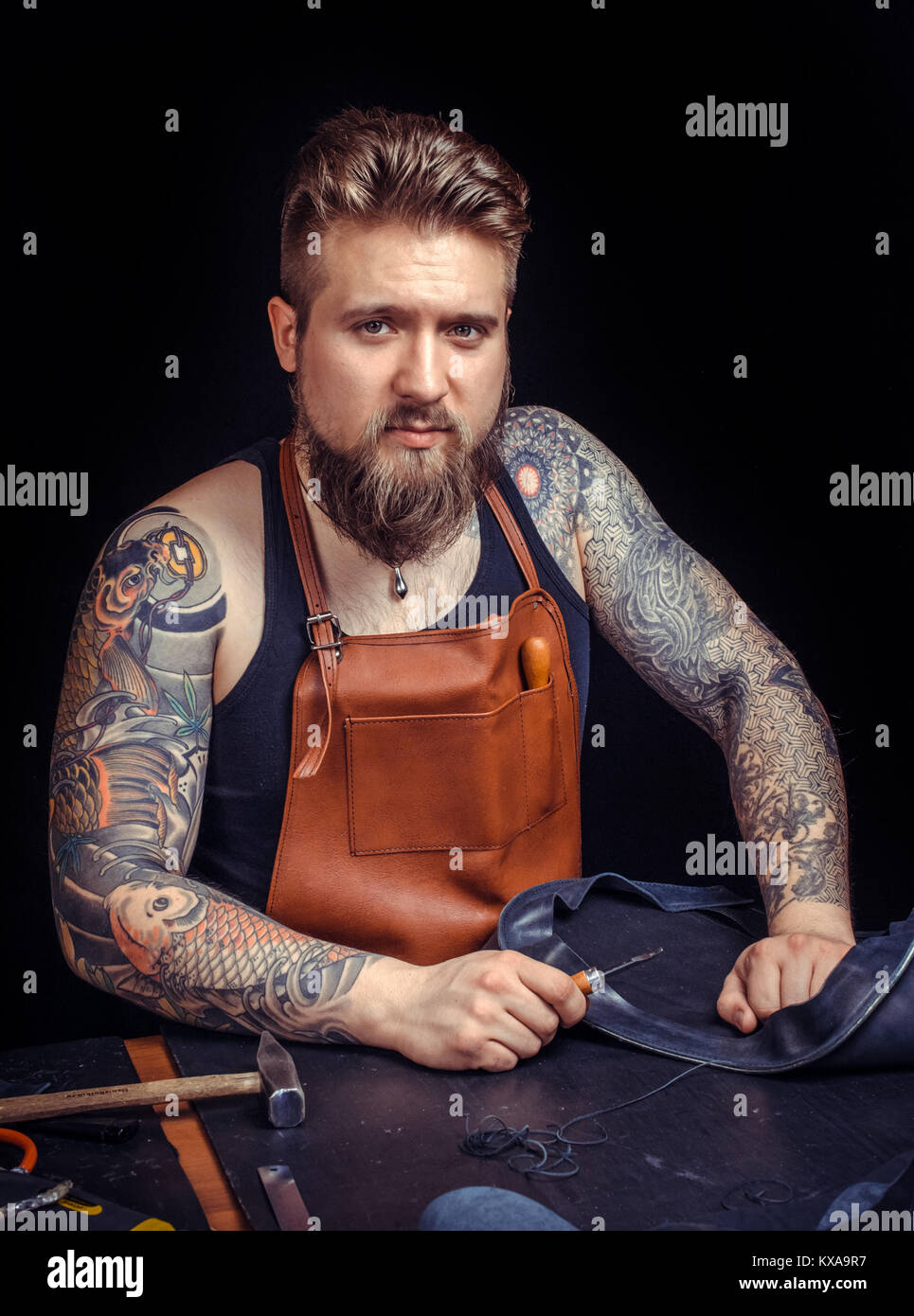 Worker of leather working with leather using crafting tools at the ...