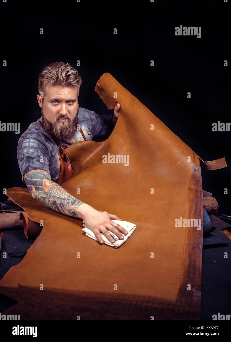 Leather master demostrating leather cutting process in the workplace ...