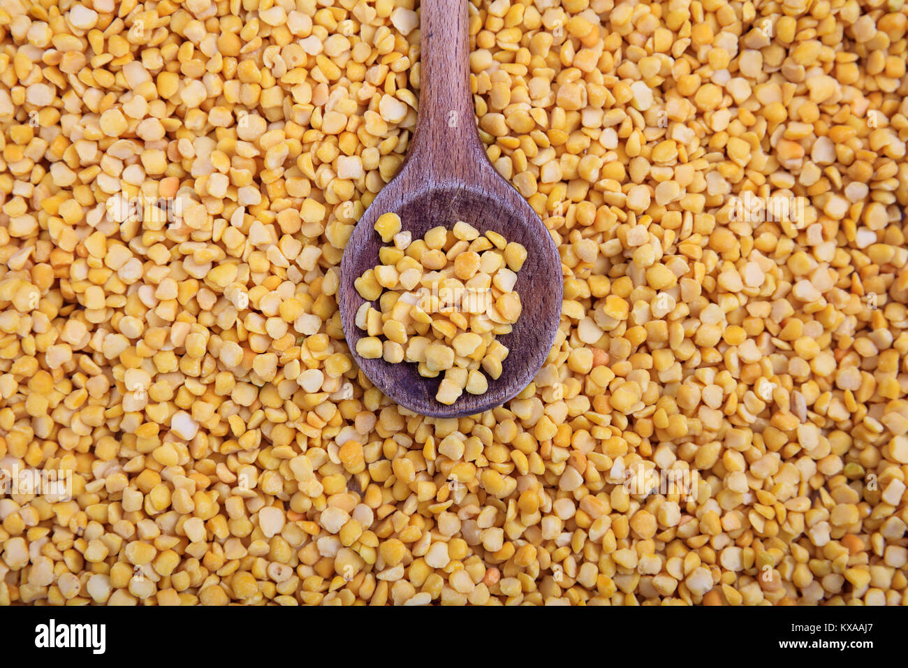 Wooden spoon on raw split peas background Stock Photo - Alamy