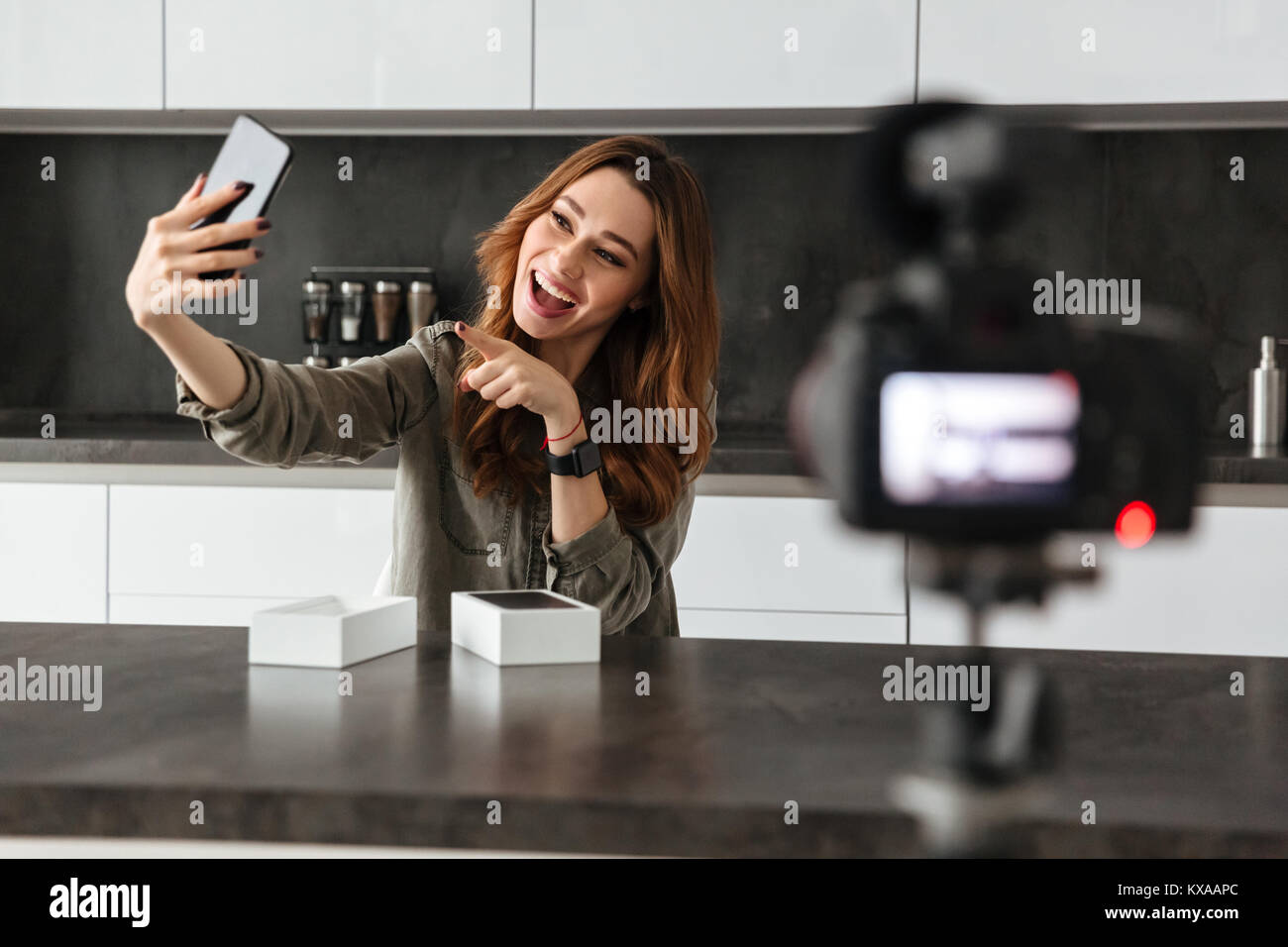Beautiful young girl recording video blog episode about new tech ...