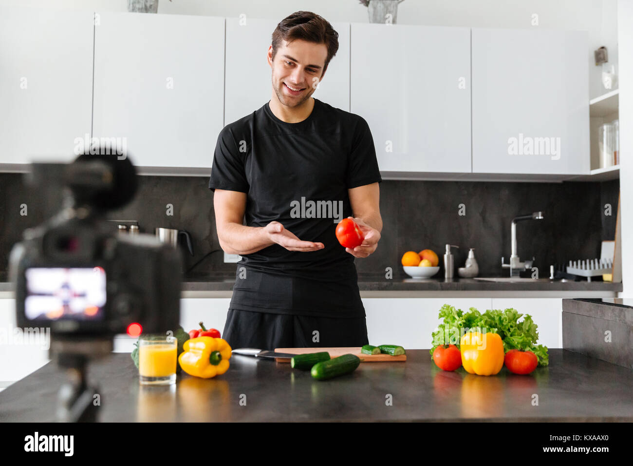Charming young man filming his video blog episode about healthy food ...