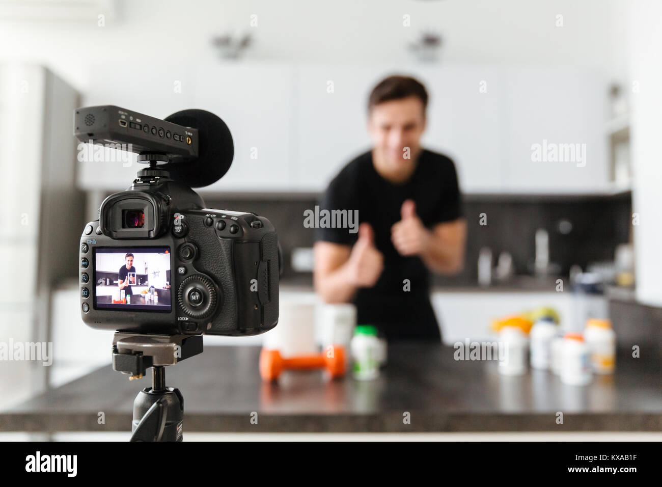Smiling young man filming his video blog episode about healthy food ...