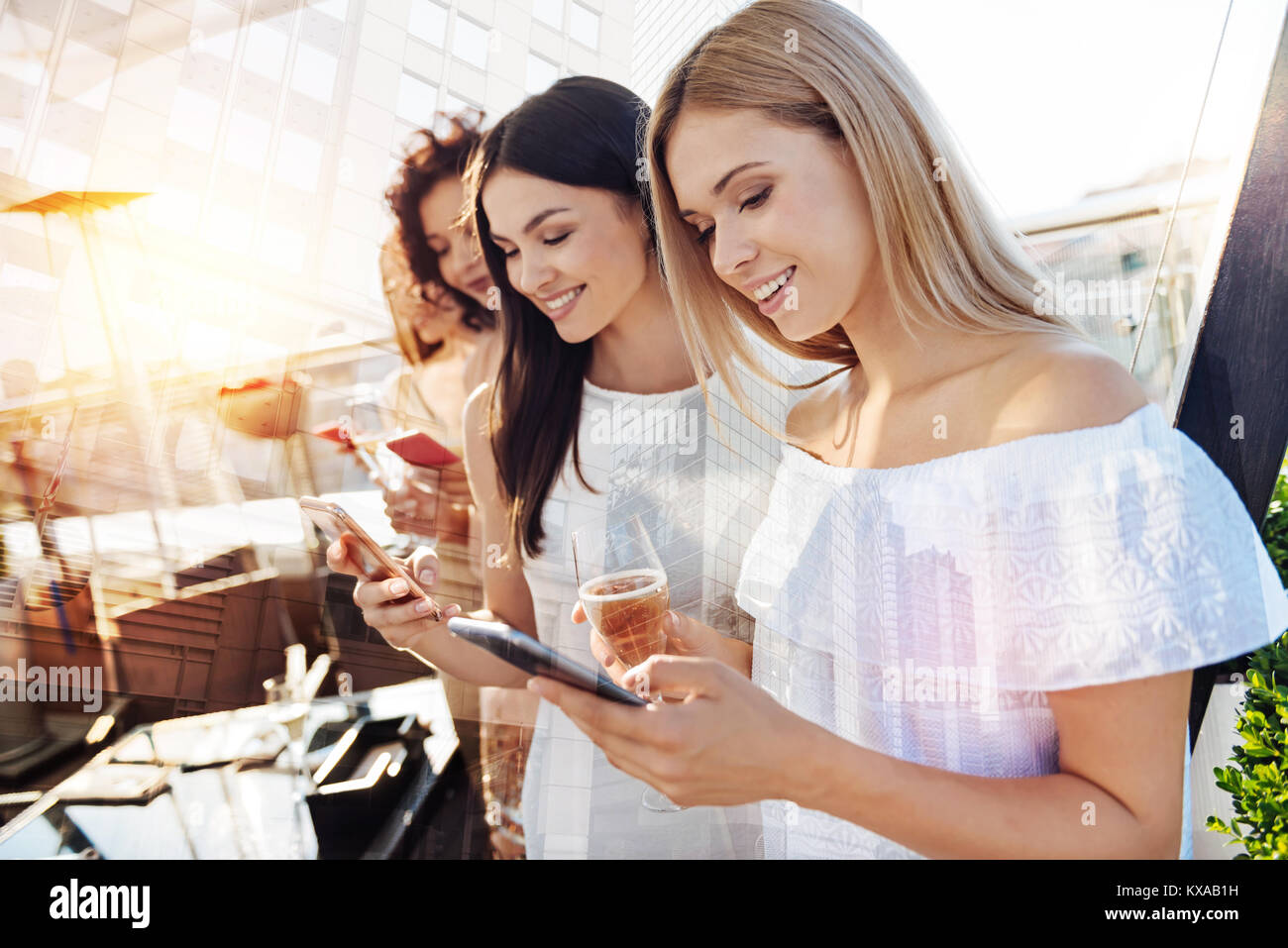 Attentive girls looking downwards at their telephones Stock Photo - Alamy