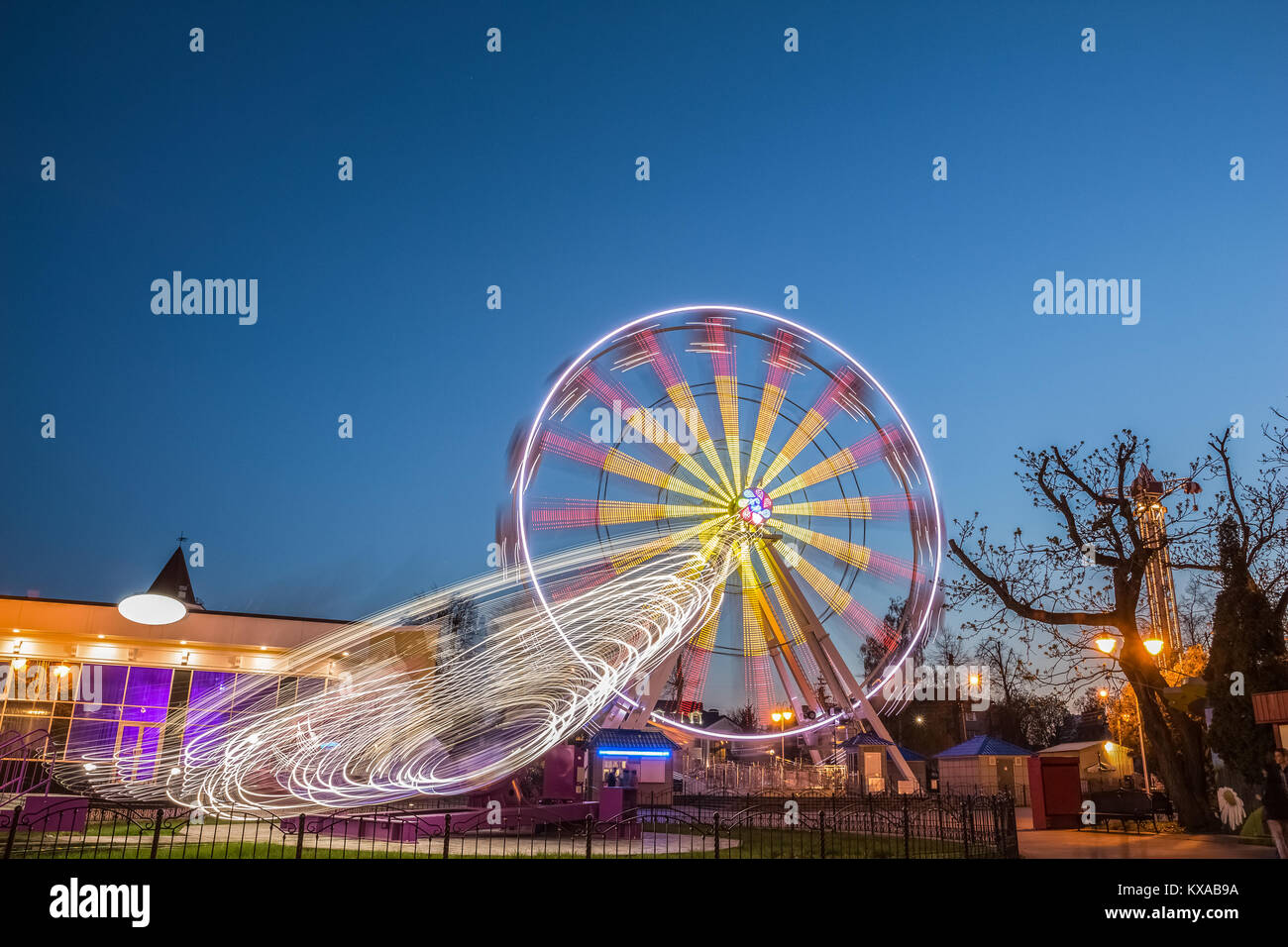 Rotating attractions in at slow shutter speeds on a background of blue ...