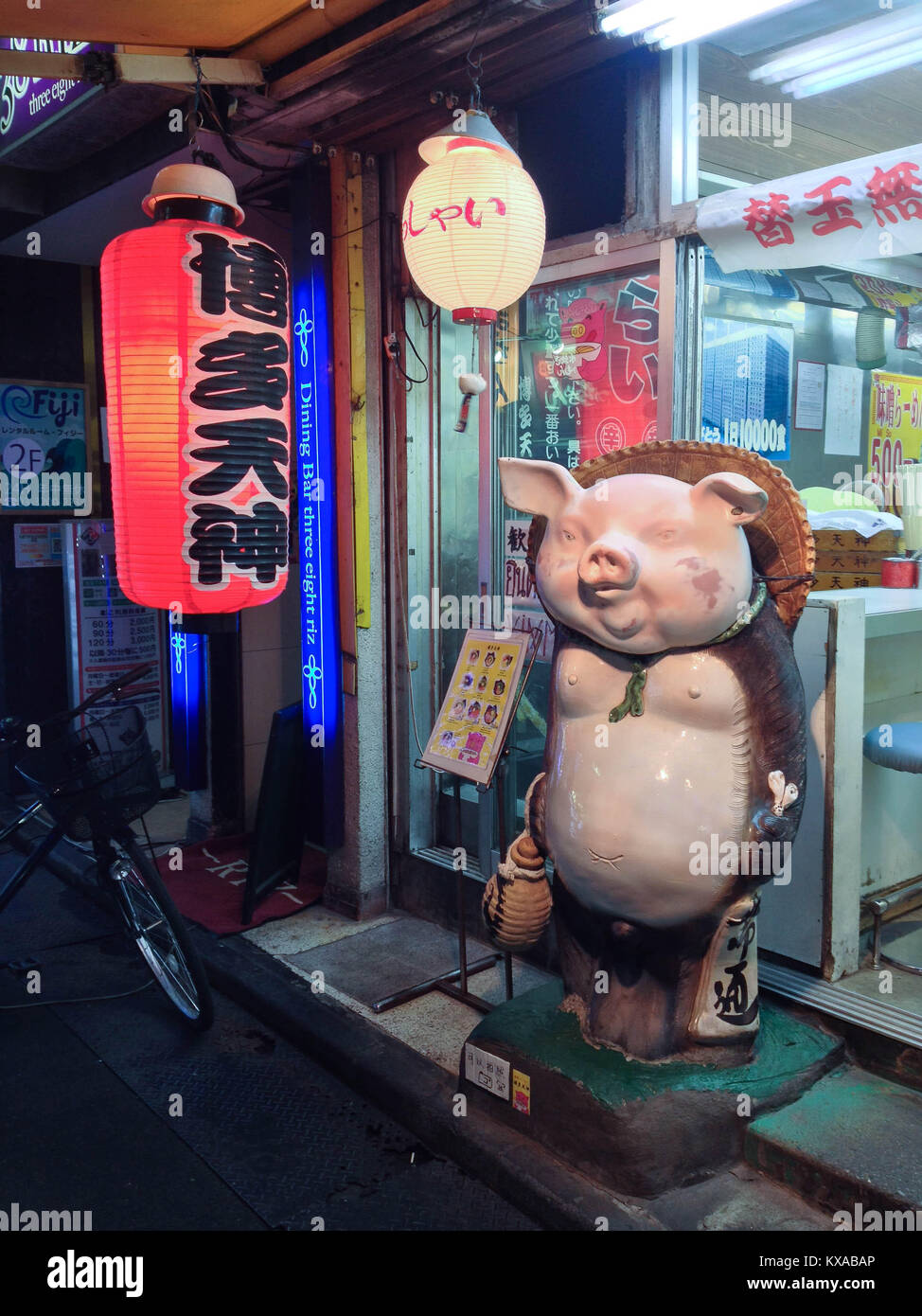 Japanese storefront with a large pig statue with straw hat, a big red ...