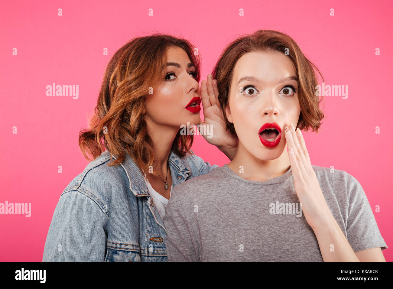 Photo of shocked two women friends standing isolated over pink ...