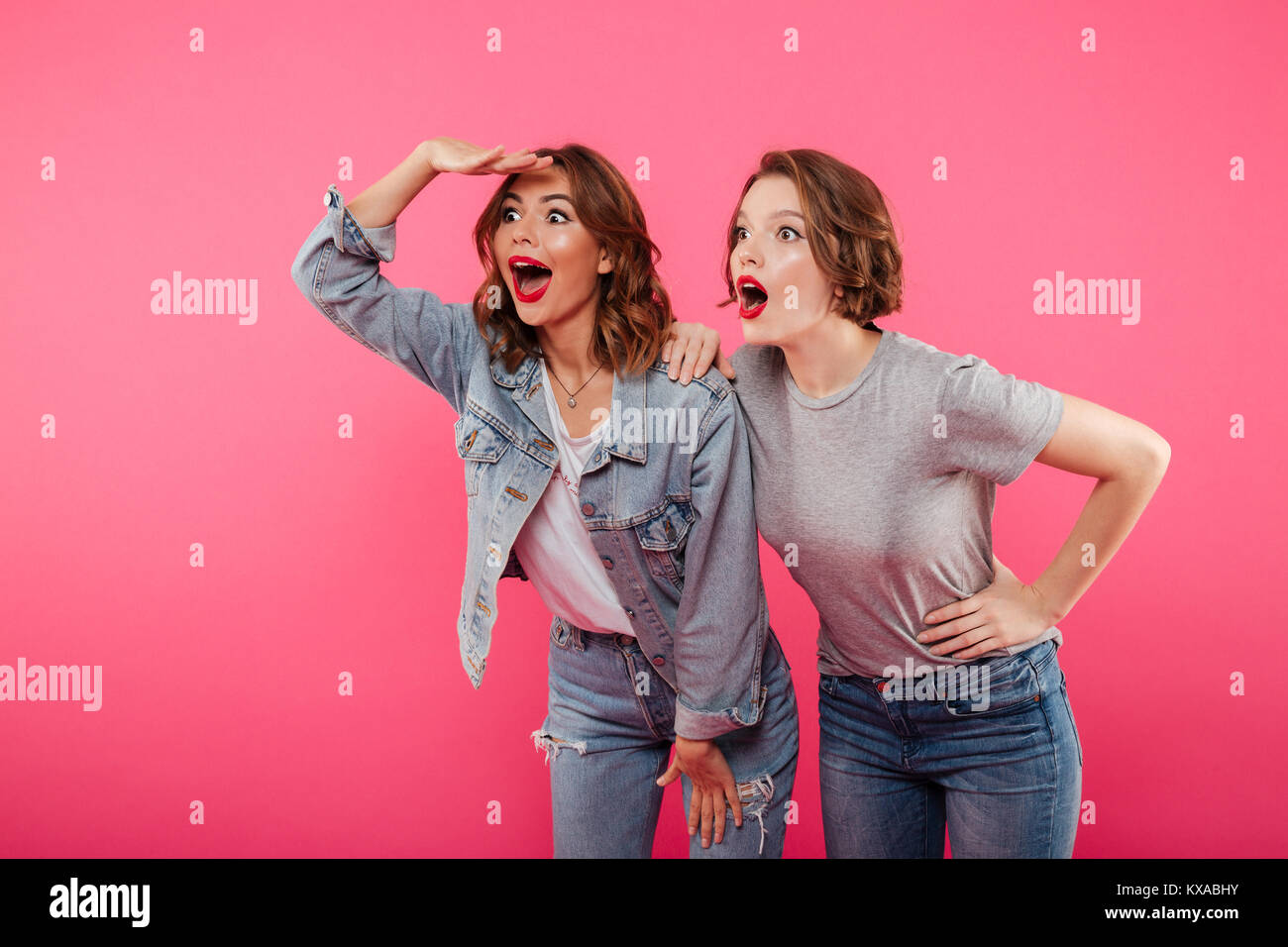 Image of two emotional ladies friends standing isolated over pink ...