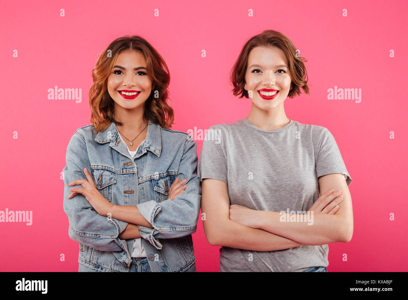 Photo of happy two emotional women friends standing isolated over pink ...