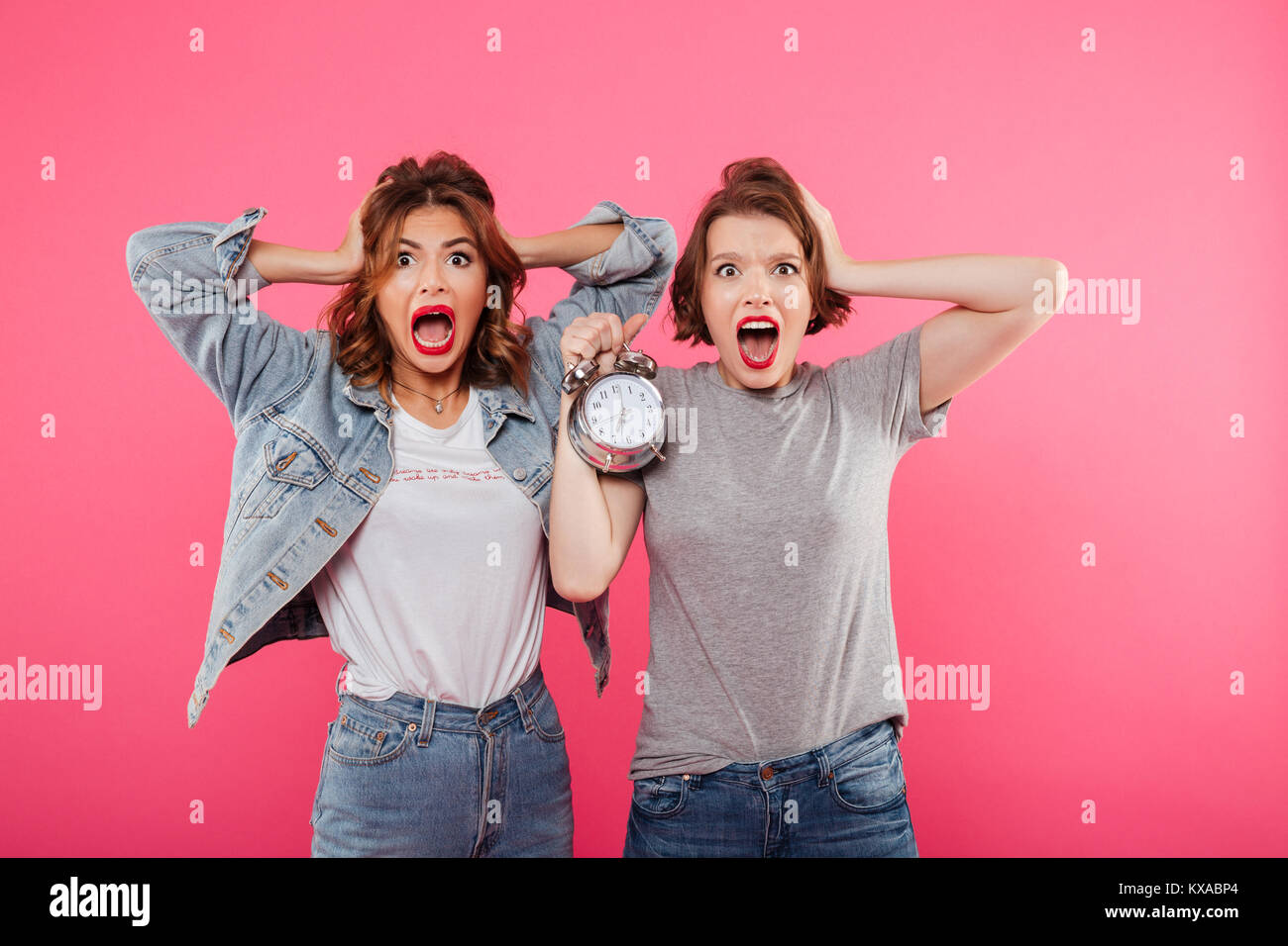 Image of two shocked women friends standing isolated over pink ...