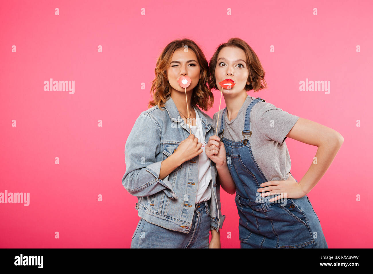 Image of two funny women friends standing isolated over pink background ...