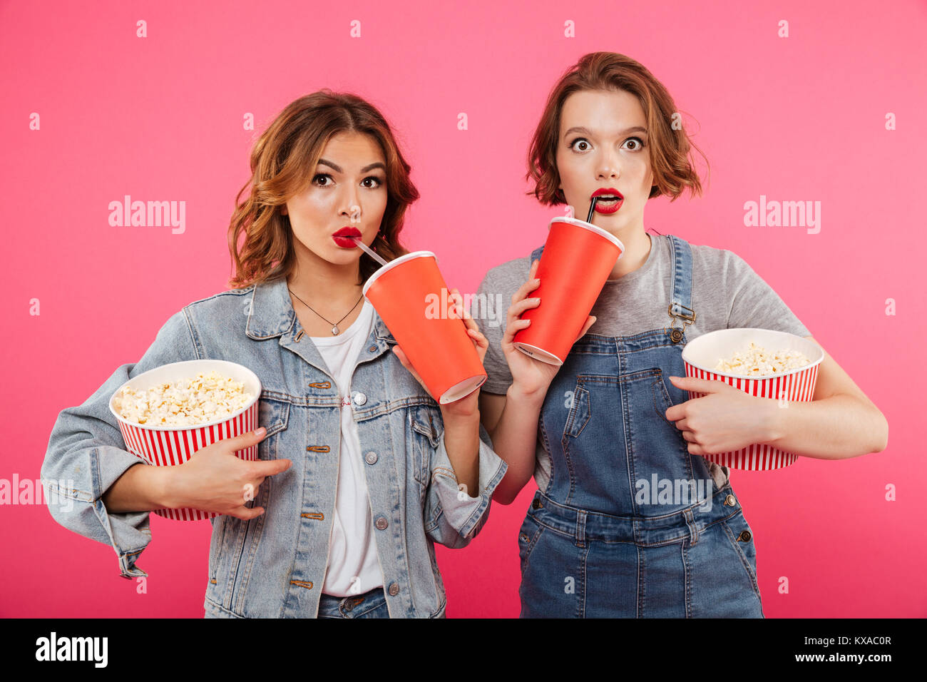 Photo of two shocked women friends standing isolated over pink ...