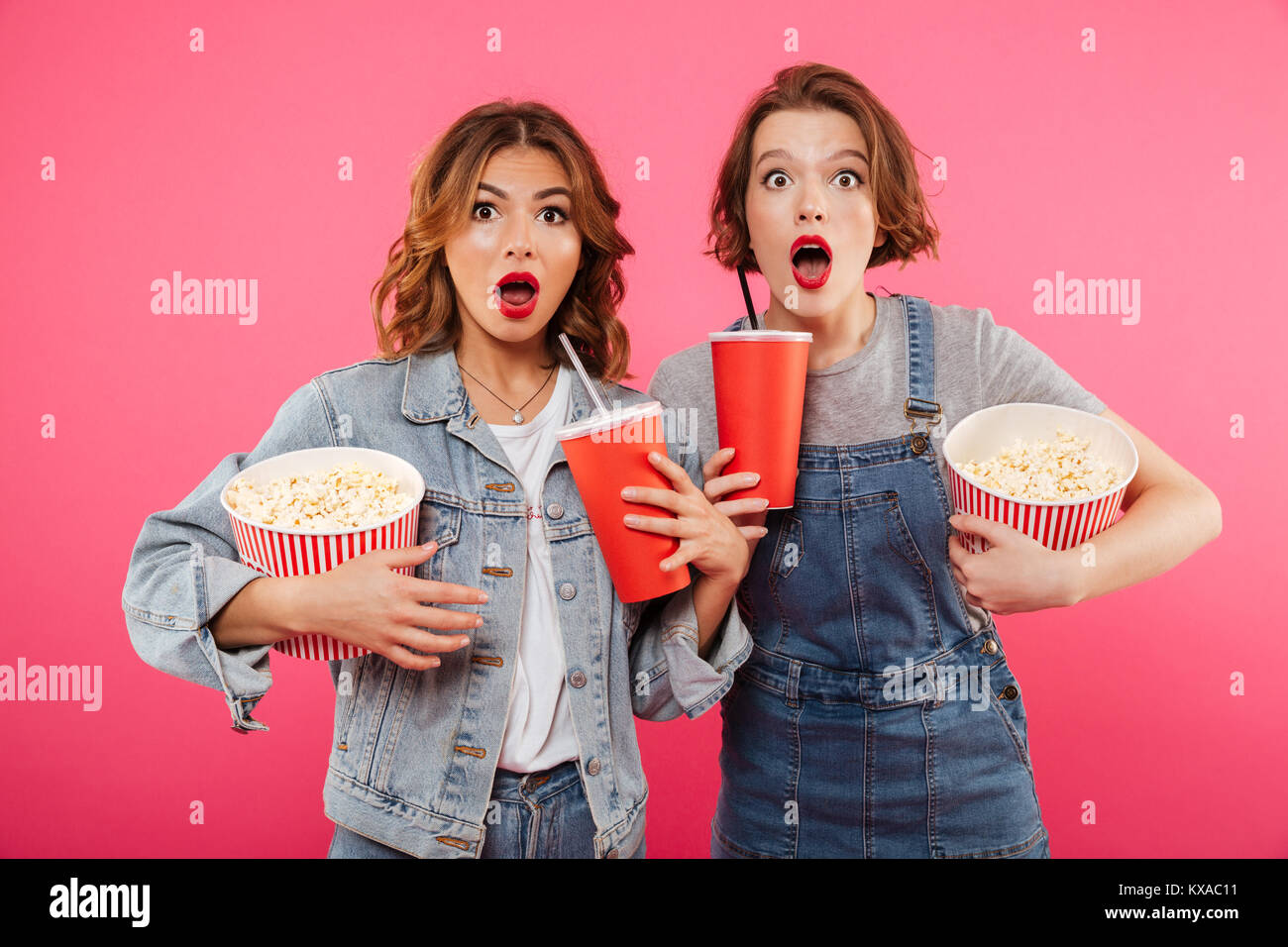 Photo of two shocked women friends standing isolated over pink ...