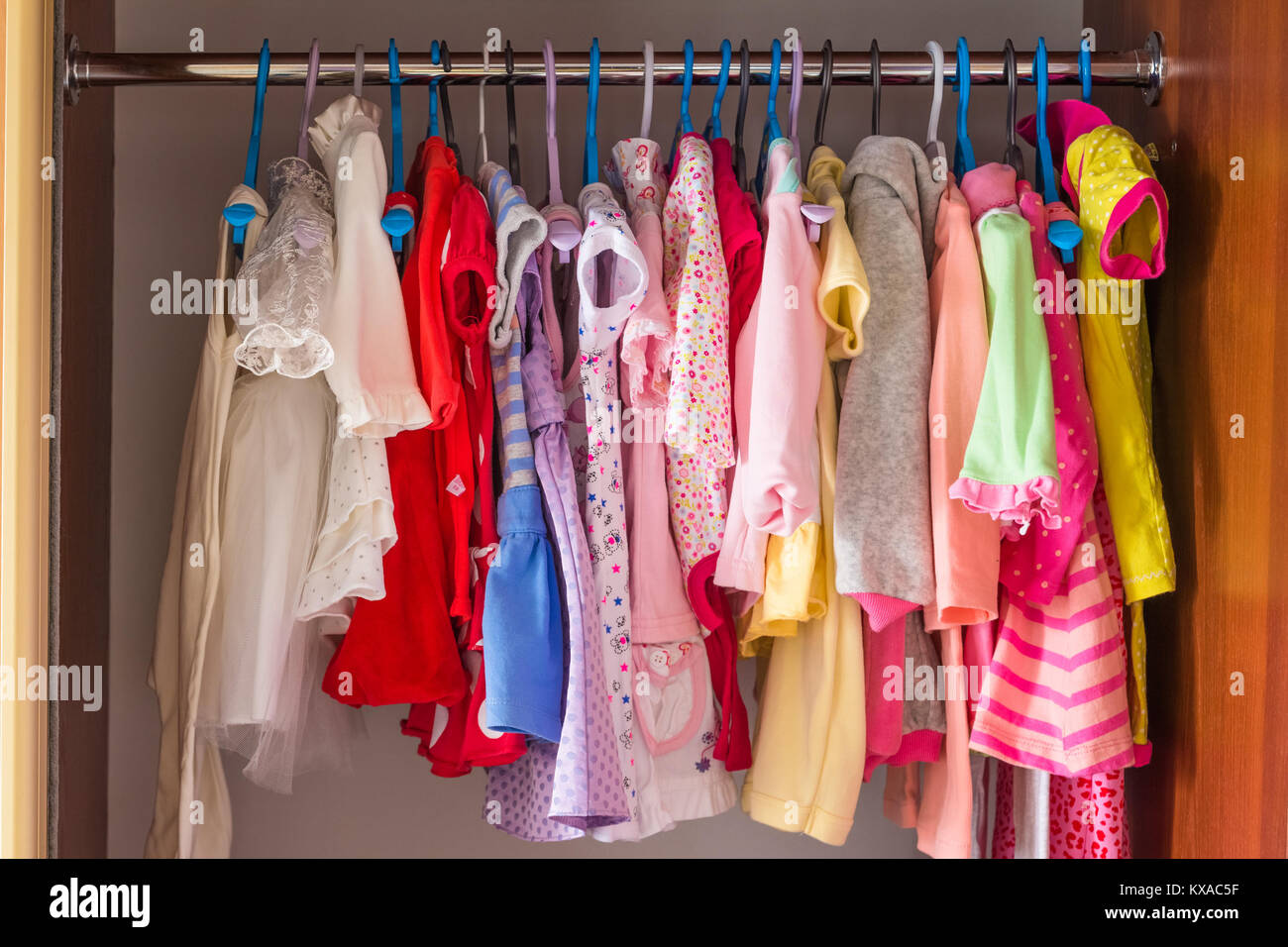 Bright colored children's clothes in the closet Stock Photo - Alamy