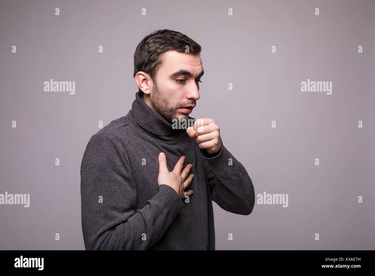 Young handsome man coughing on gray background Stock Photo - Alamy
