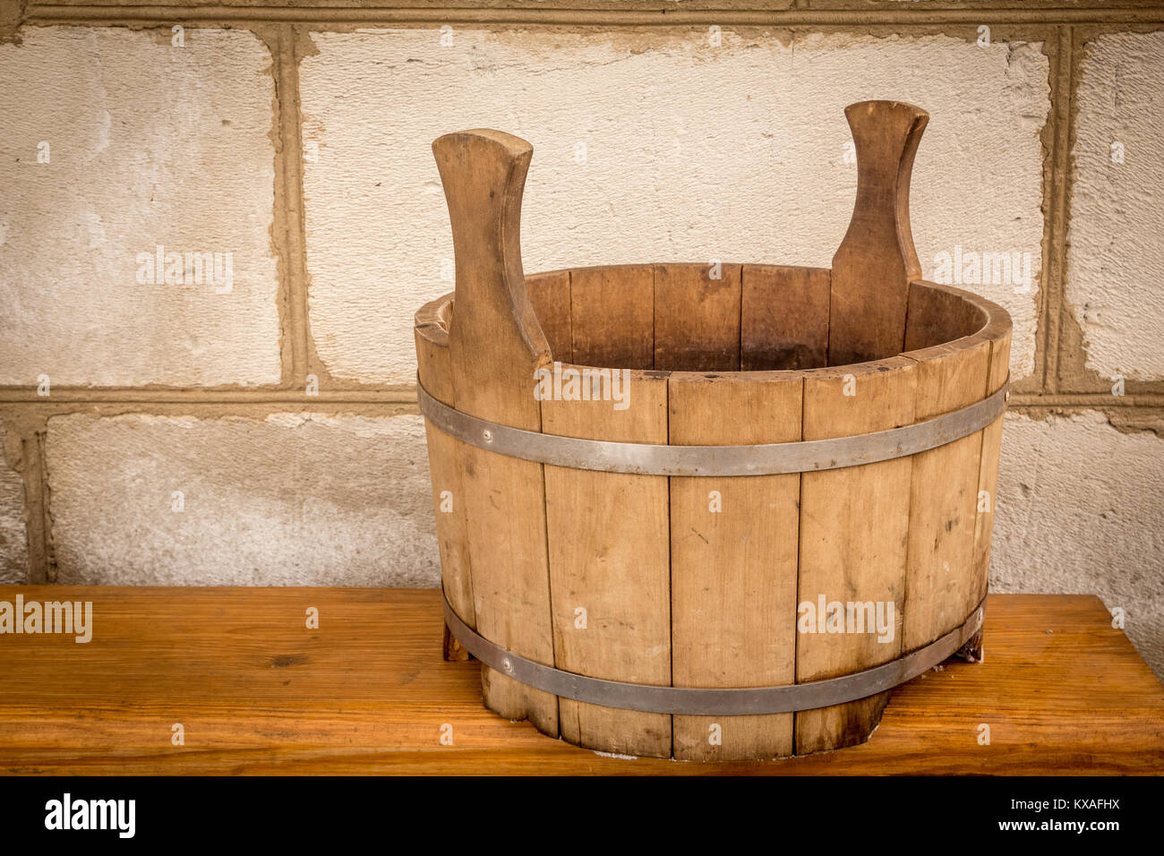 Old wooden bucket on the bench against the wall Stock Photo - Alamy