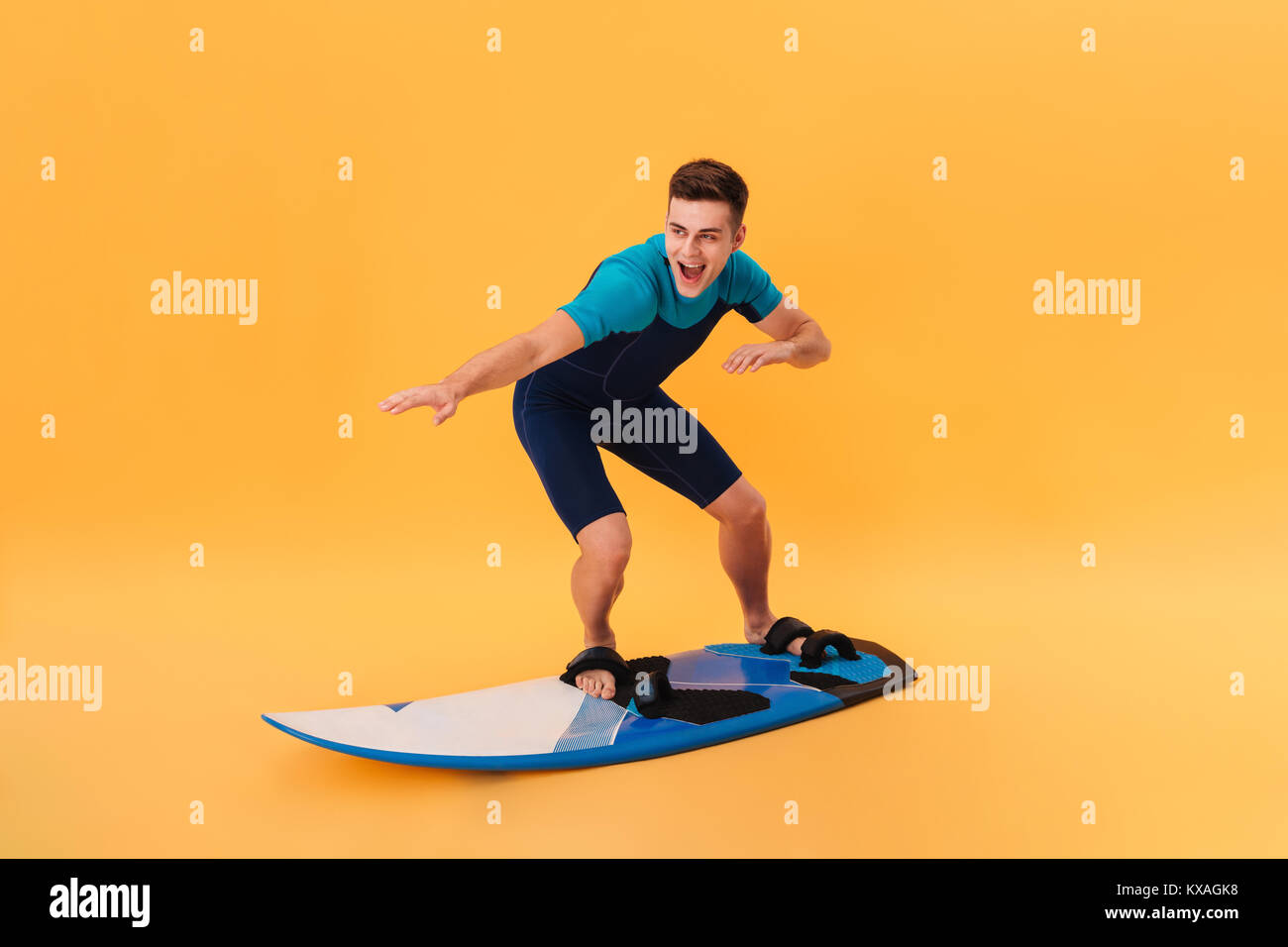 Picture of a Happy surfer in wetsuit using surfboard like on wave over ...