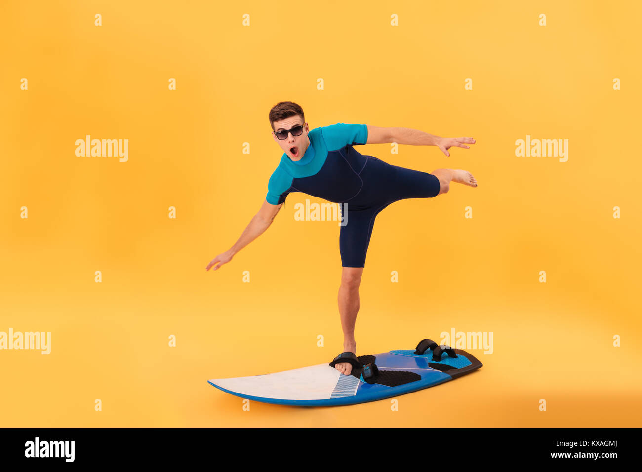 Picture of Funny surfer in wetsuit and sunglasses using surfboard like ...