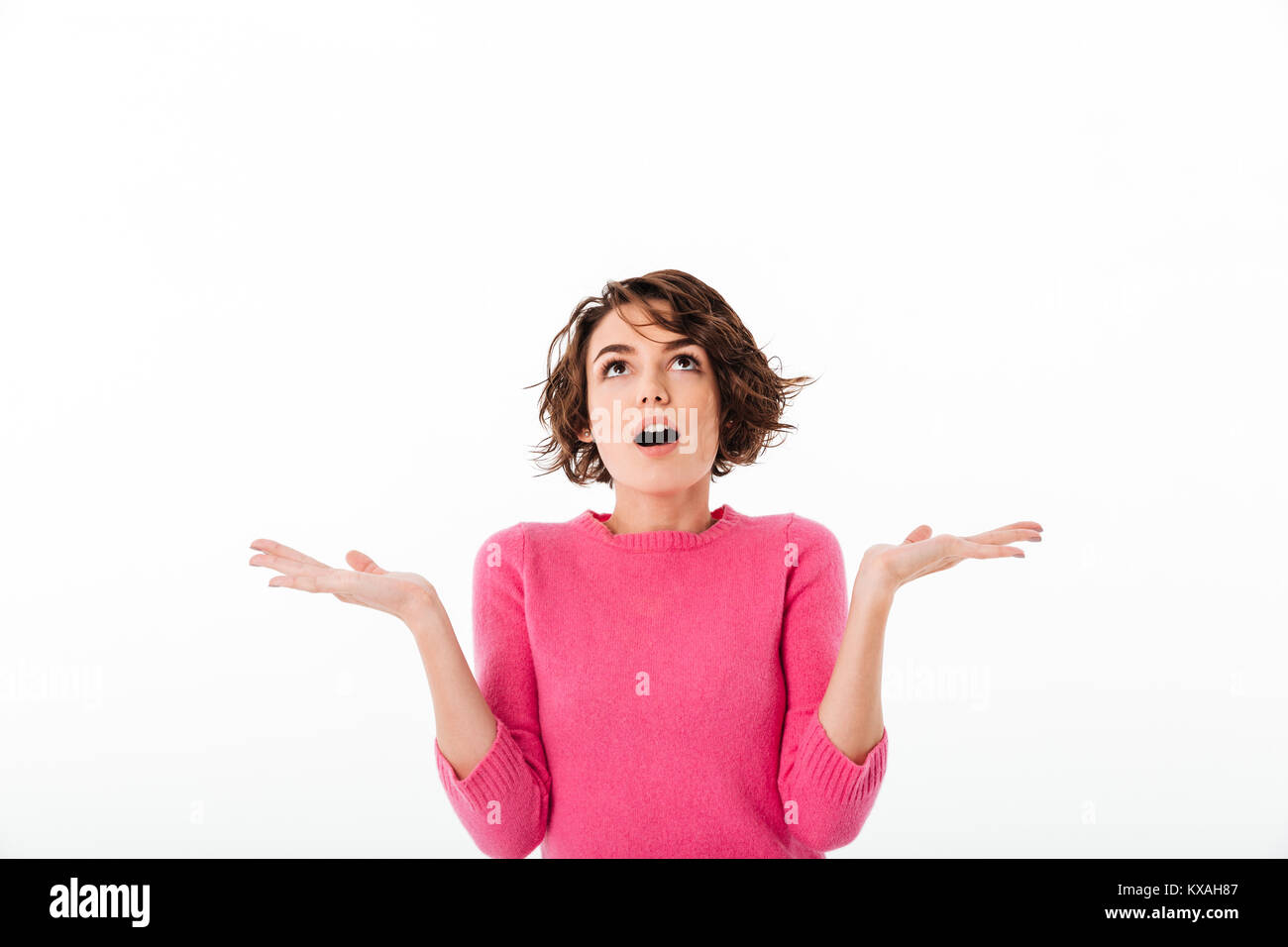 Portrait of an excited young girl shouting and looking up at copy space ...