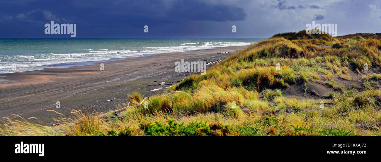 Sandy beach beach, grass covered dunes, storm clouds, Waiinu Beach ...