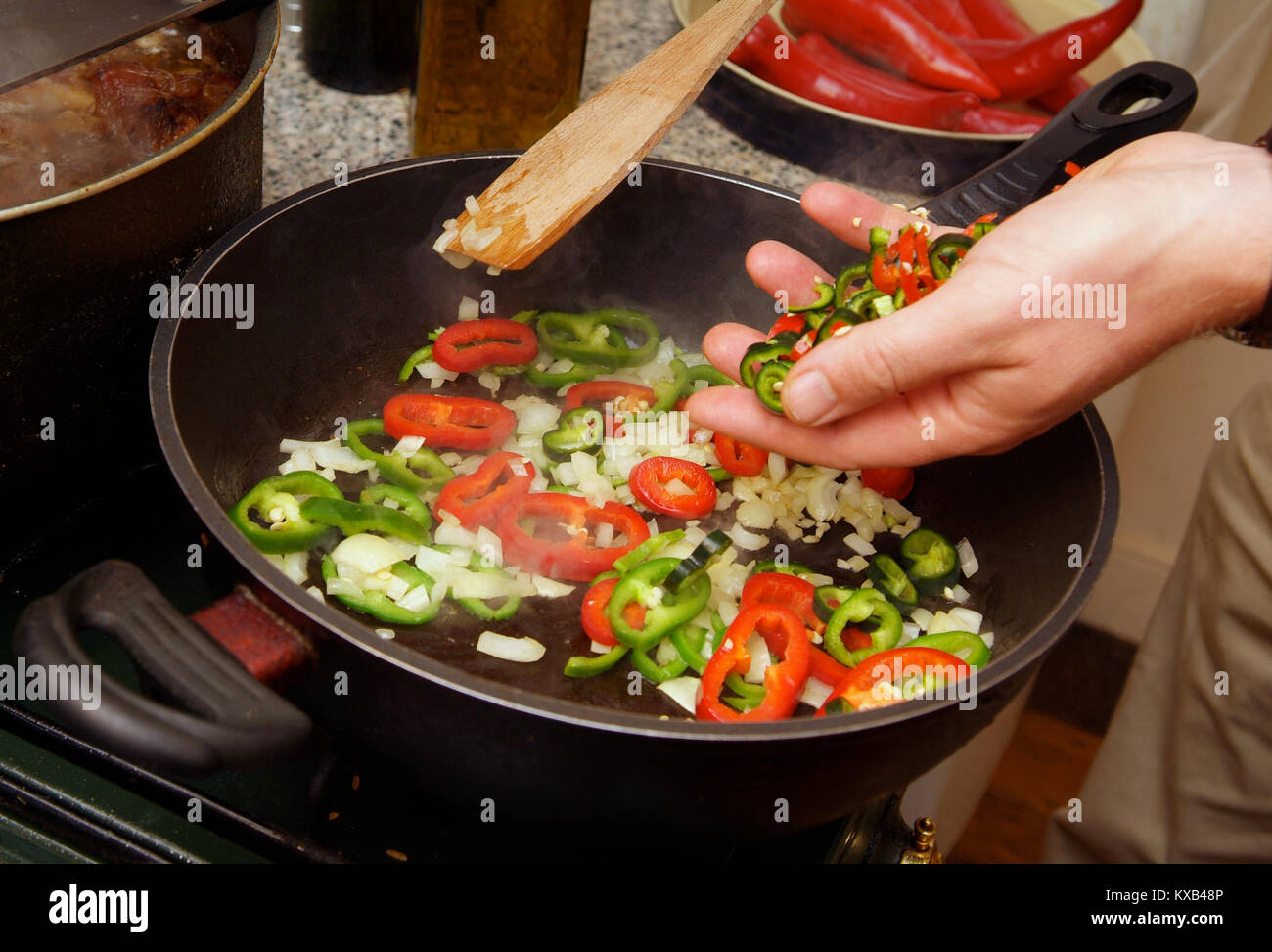 Cooking chillies in a frying pan Stock Photo - Alamy