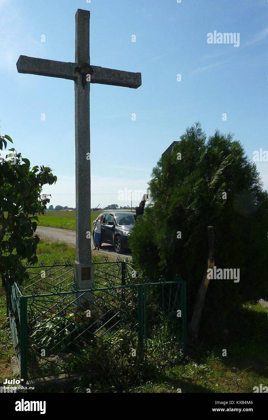 This image shows a roadside cross in Grabówka, Poland. It is a ...