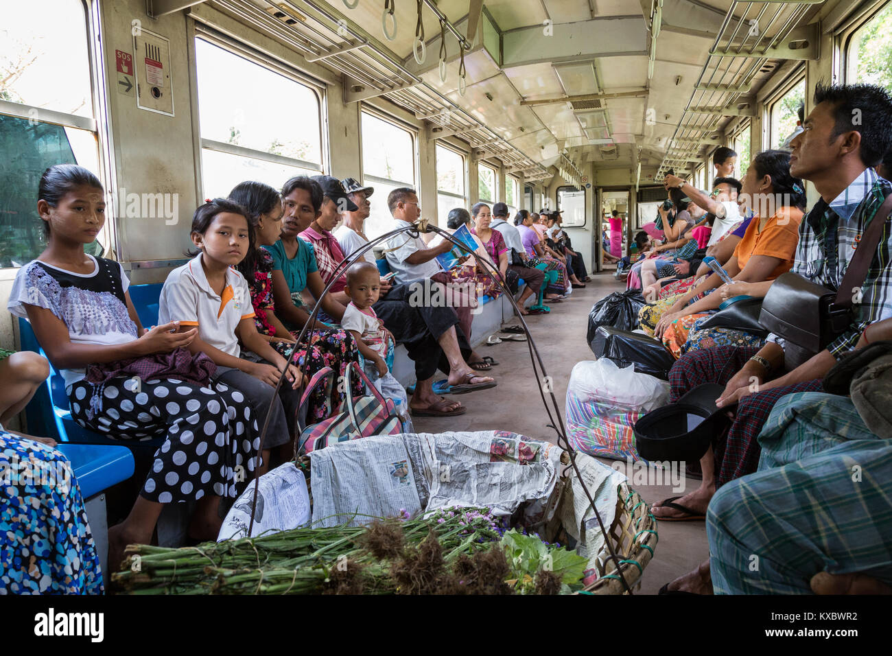 Myanmarese men, women and children onboard a commuter train on the ...