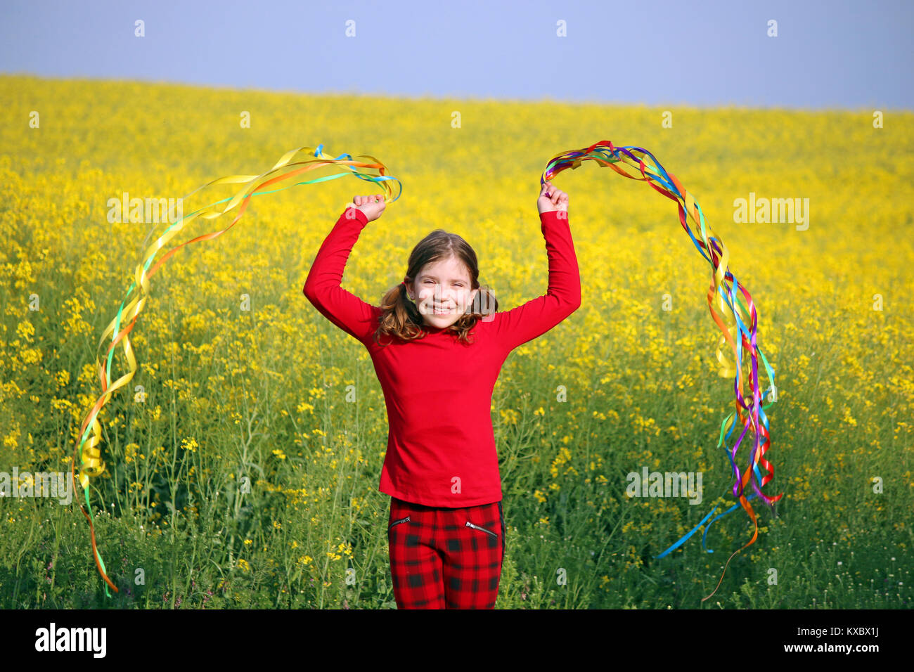 happy little girl playing on field spring season Stock Photo - Alamy