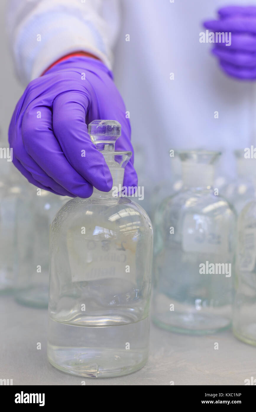 Lab chemist holding reagent bottle Stock Photo - Alamy