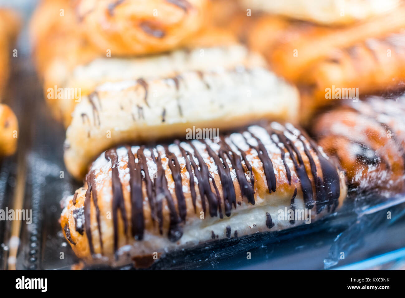 Macro closeup display of chocolate covered drizzled croissant pastries ...