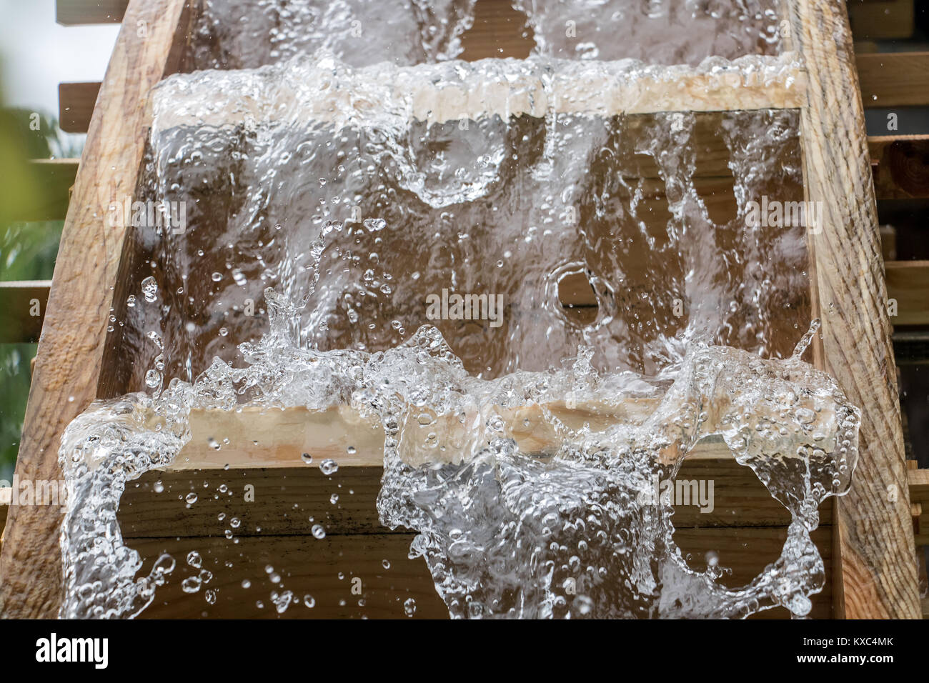 The blades of mill wheel rotates under a stream of water, close up view ...