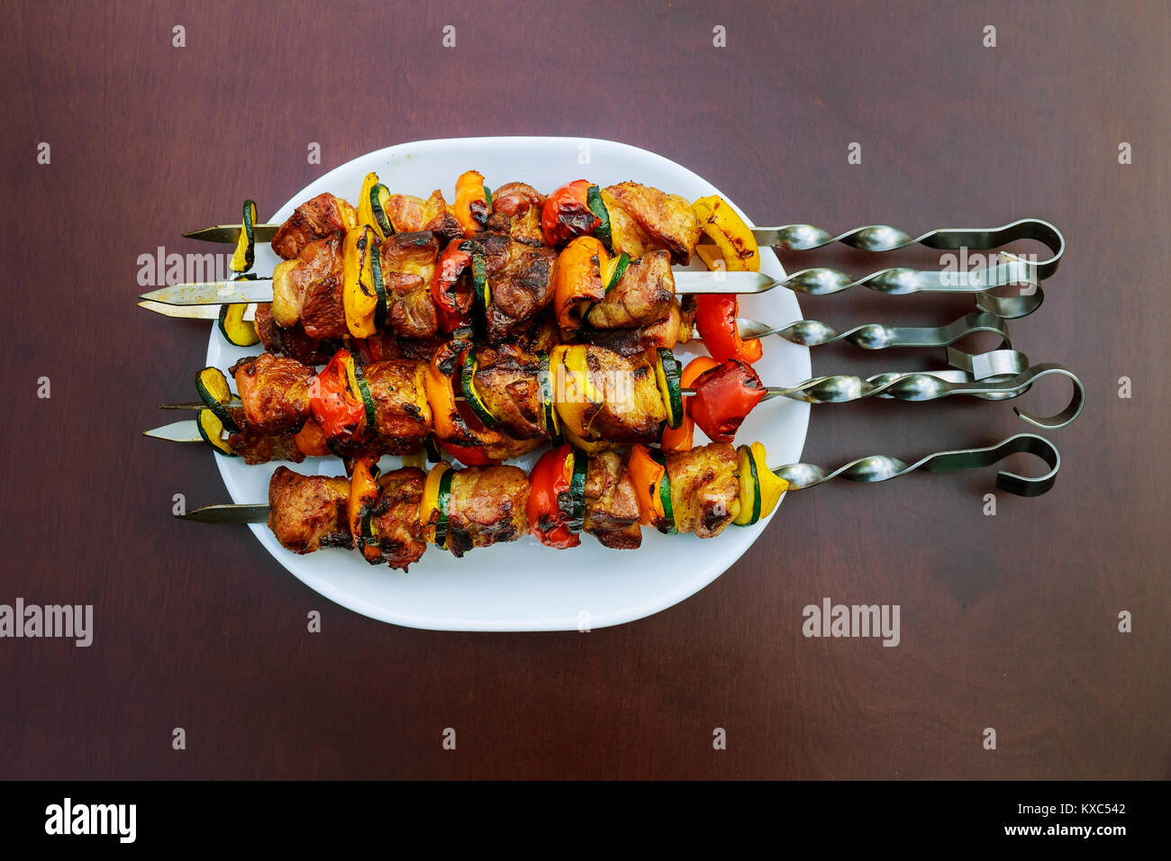 Grilled kebab cooking on metal skewer closeup. Roasted meat cooked at ...