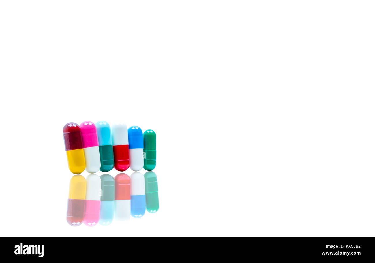 Antibiotic capsules pills in a row on white background with shadows and ...