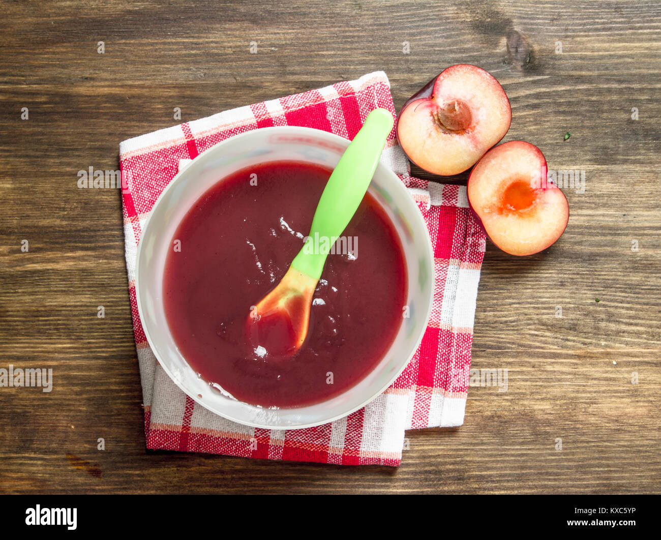 Baby food. Baby puree from fresh plums. On a wooden background Stock ...