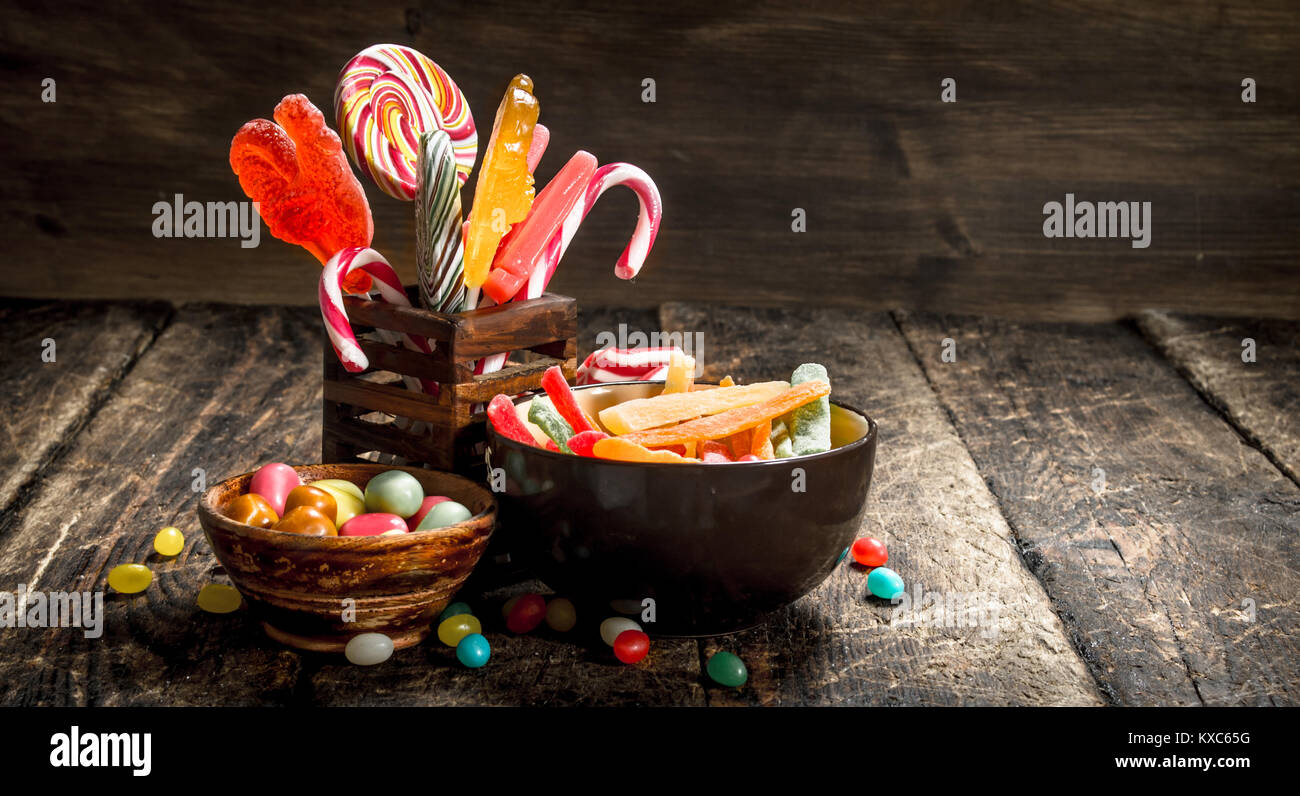 Different sweet candy in bowls. On a wooden background Stock Photo - Alamy
