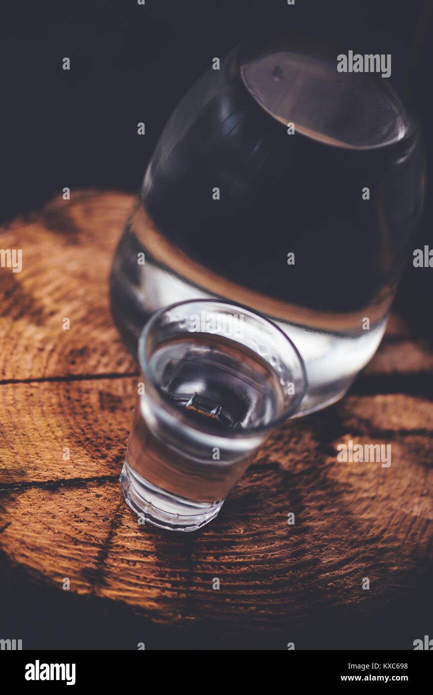 Strong alcohol drink in bottle with shot glass in traditional rustic ...