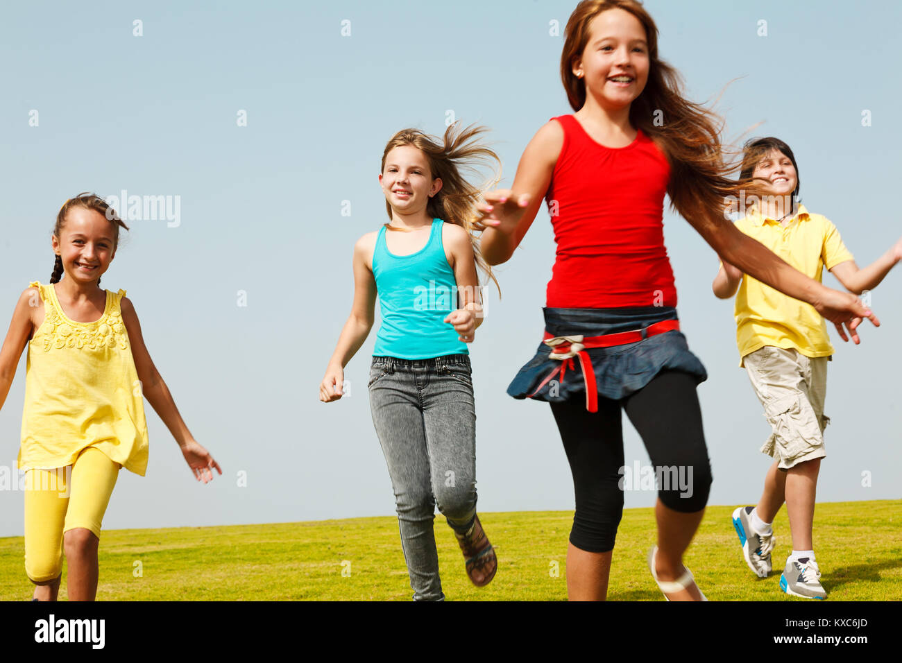 Group of four happy children running outside Stock Photo - Alamy